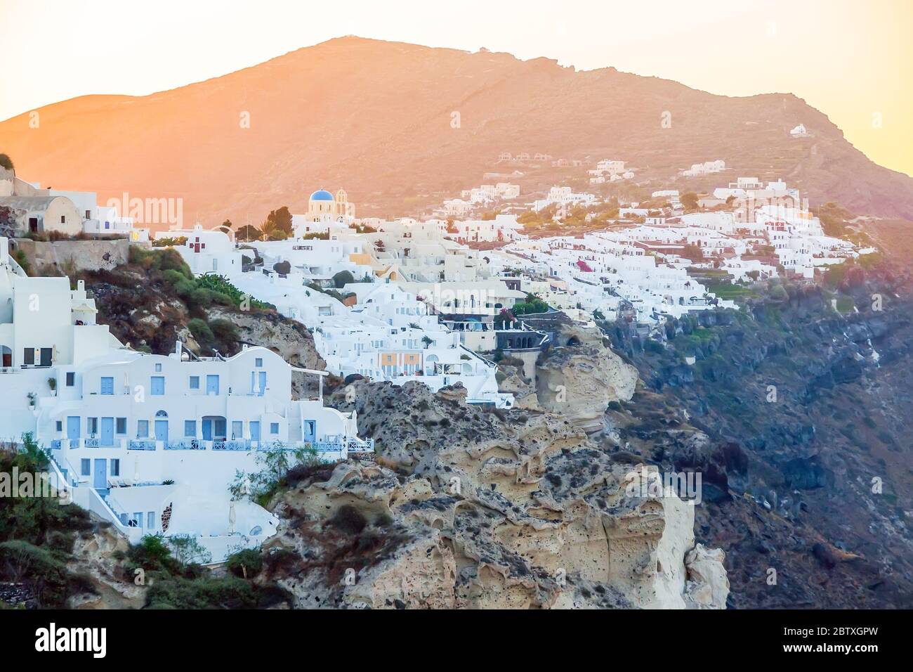 Traditional white cave houses on a cliff on the island Santorini ...