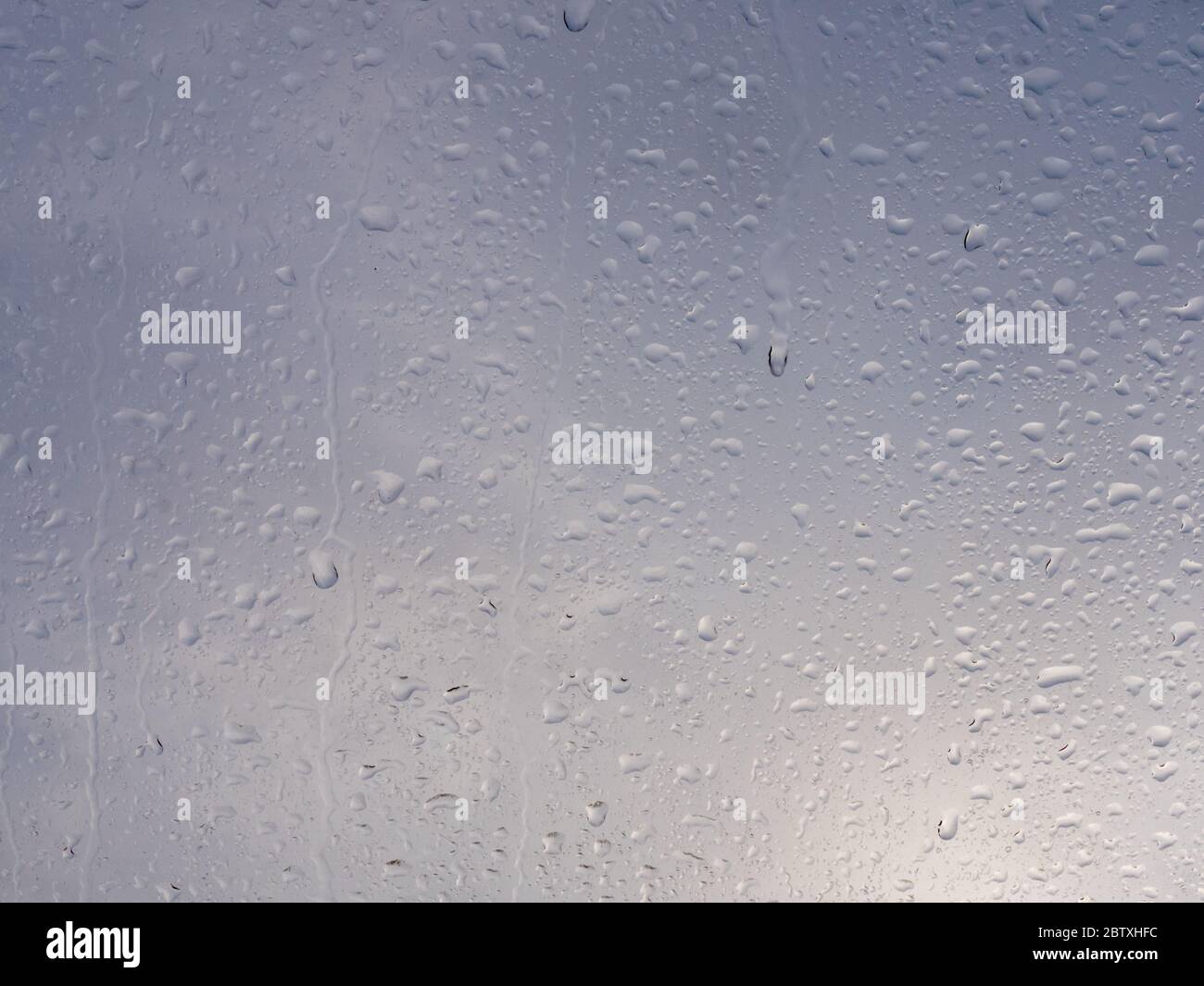 Wet window with rain drops and a cloudy sky outside background Stock ...