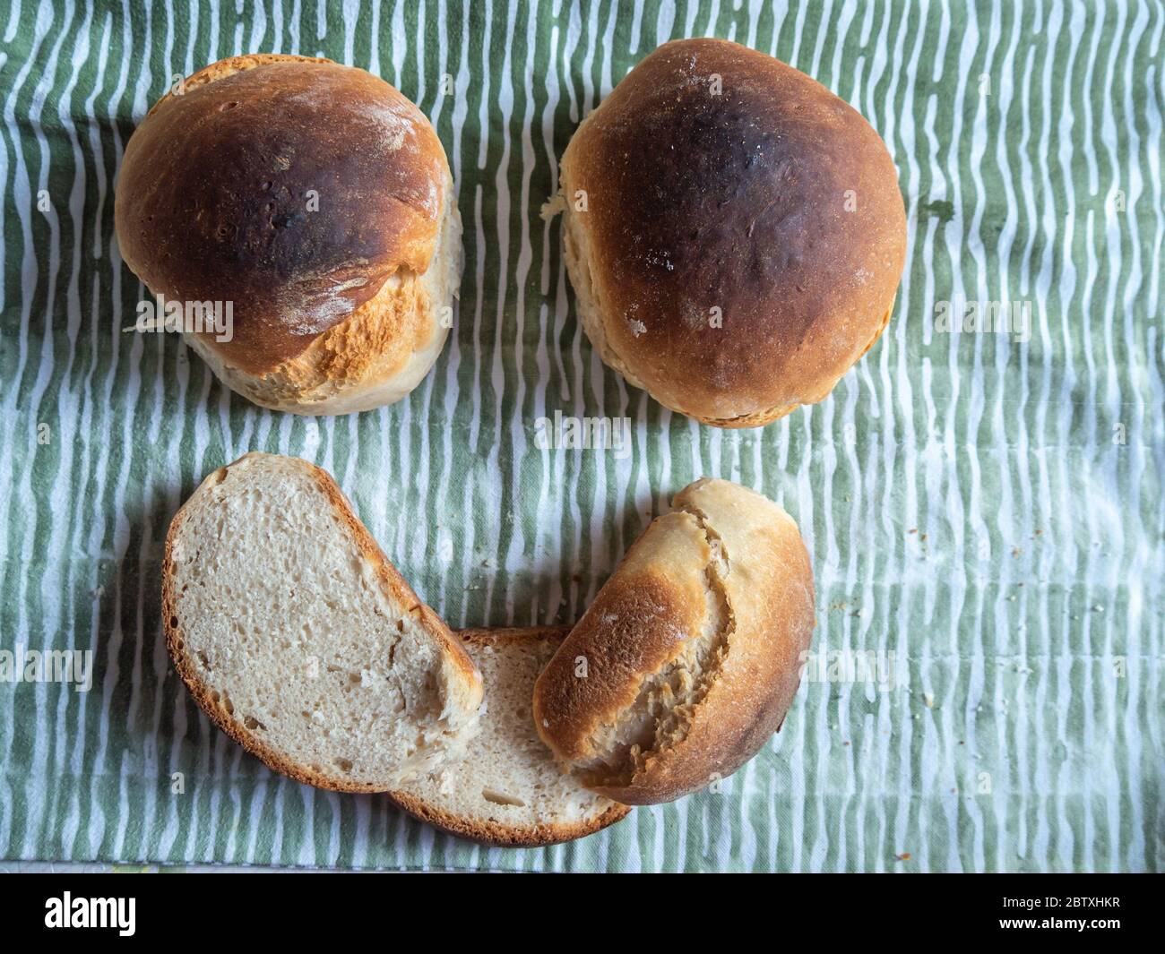 Freshly baked sliced bread on the table smiling face symbol. Top view ...