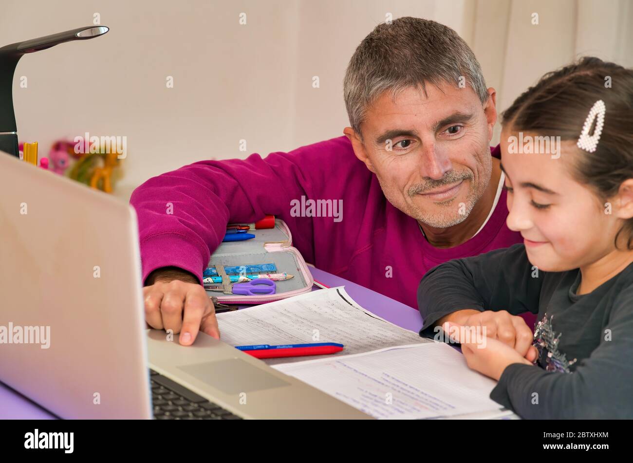 Father explaining computer utilization to her daughter at home Stock ...