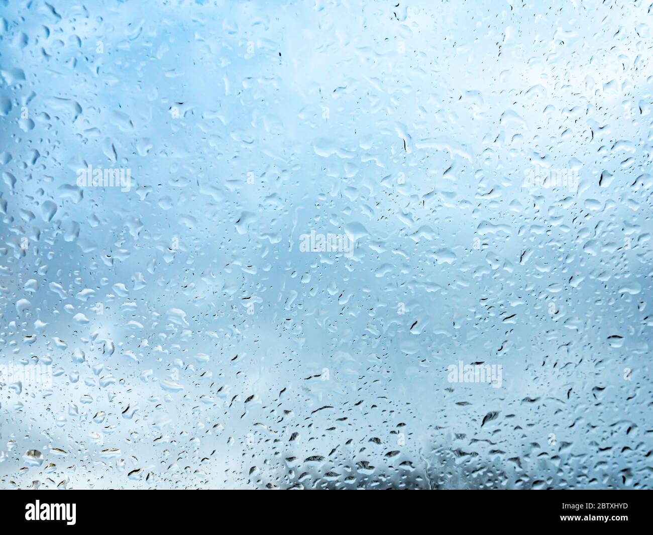 Wet window with rain drops and a cloudy sky outside background Stock ...