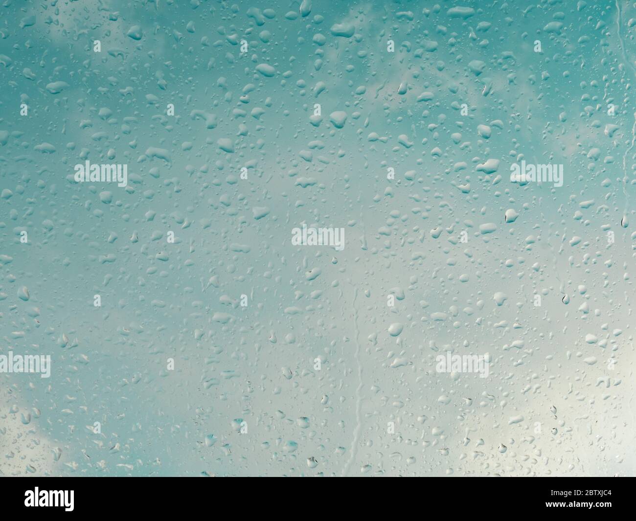 Wet window with rain drops and a cloudy sky outside background Stock ...