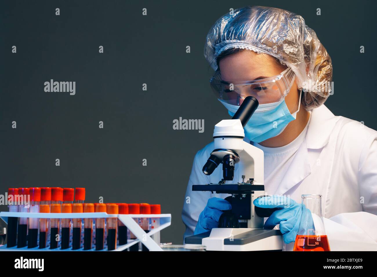 Woman scientist looking through a microscope in laboratory Stock Photo ...