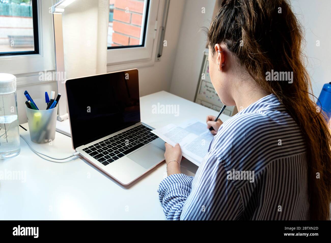 Young attractive woman doing homework sitting desktop with modern ...