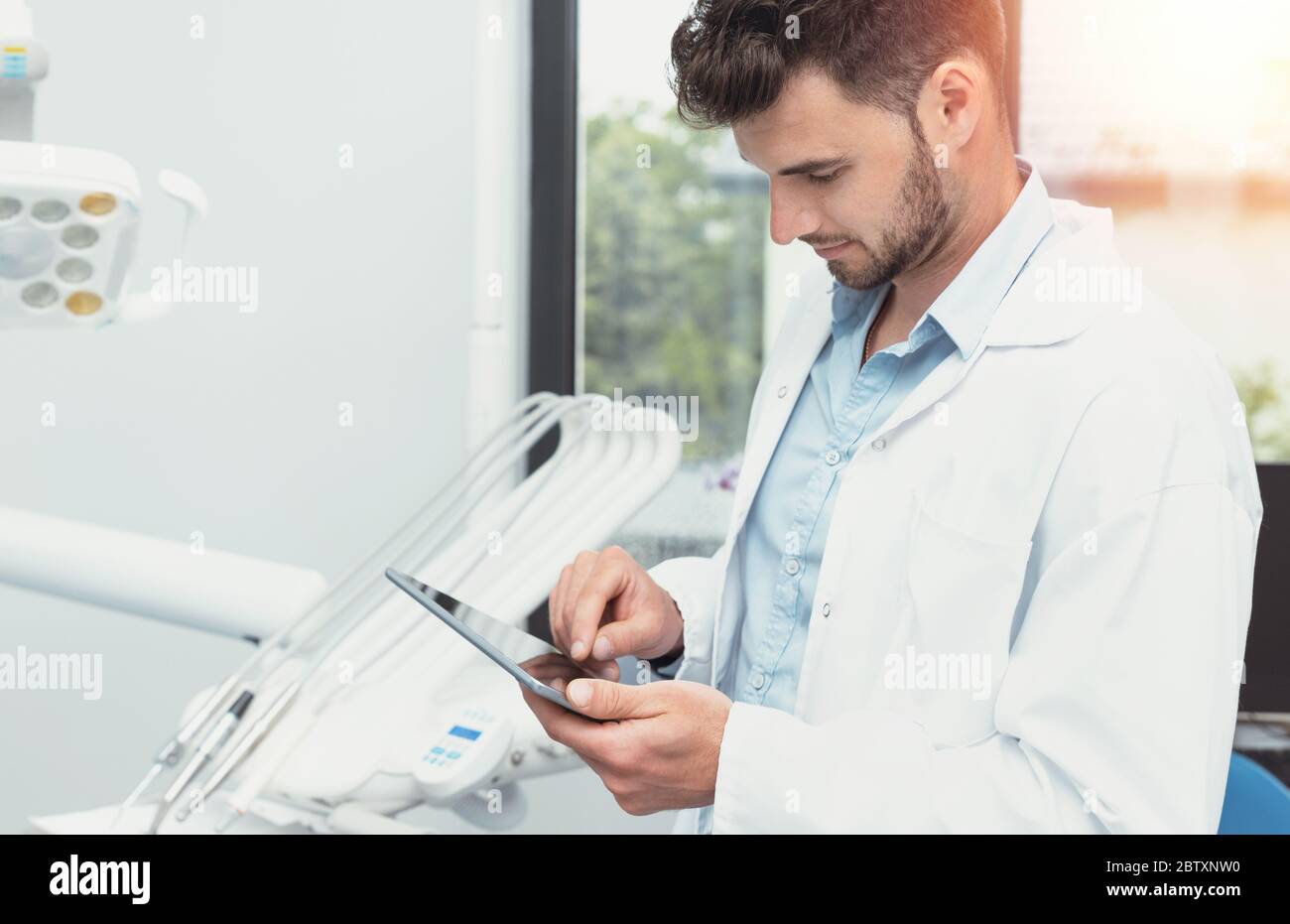 Doctor with tablet in dentist office. Telemedicine, remote health care ...