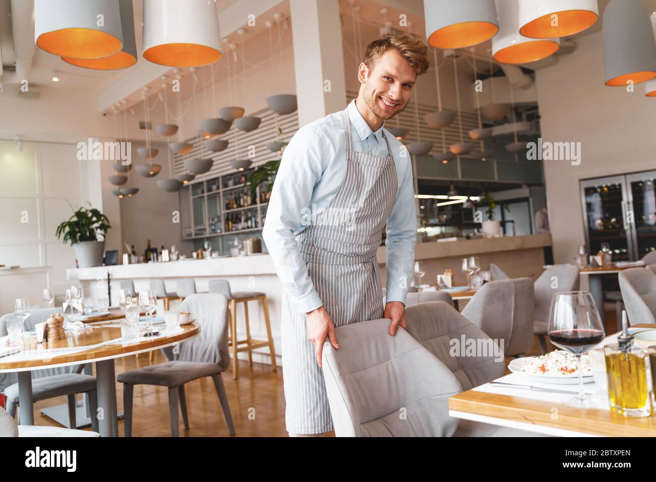Male waiter with apron hi-res stock photography and images - Alamy