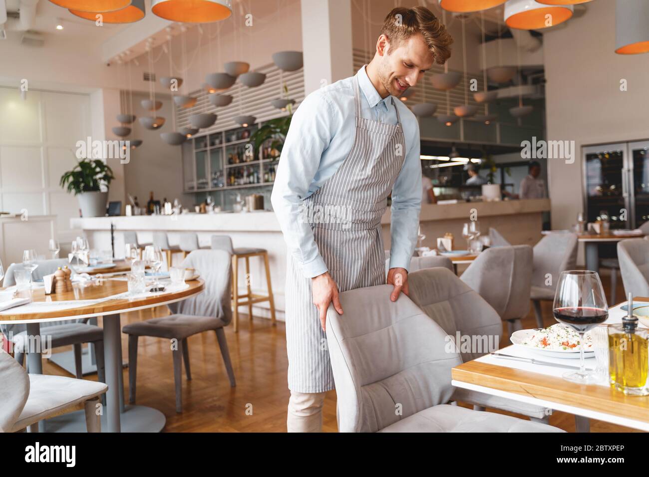 Male waiter with apron hi-res stock photography and images - Alamy