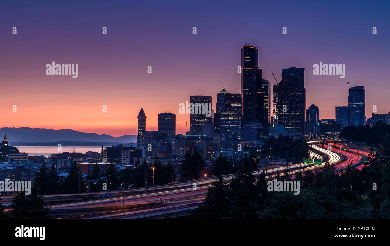 Seattle skyline, at sunset. The cars along the highway are creating ...