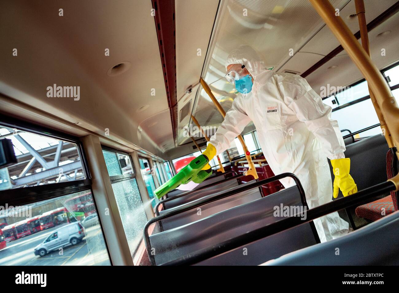 The interior of a bus is disinfected by a cleaner in protective ...