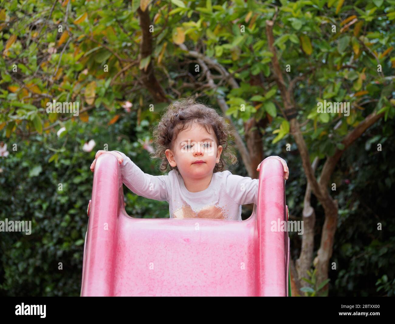 Two year old toddler plays alone outside in the garden Stock Photo - Alamy
