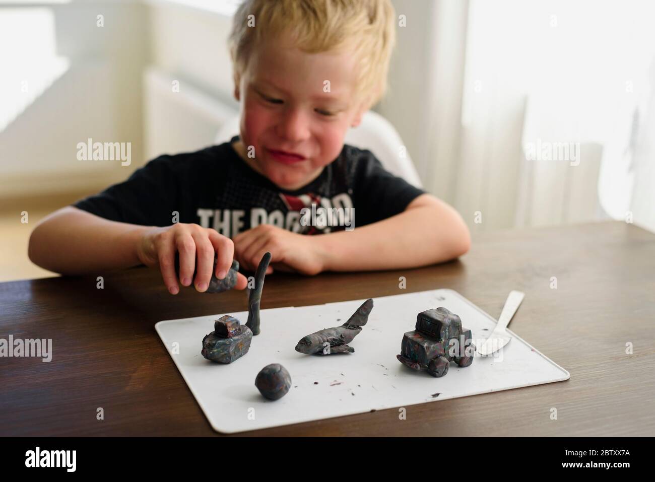 Child sculpting toy from modelling clay and playing at home Stock Photo ...