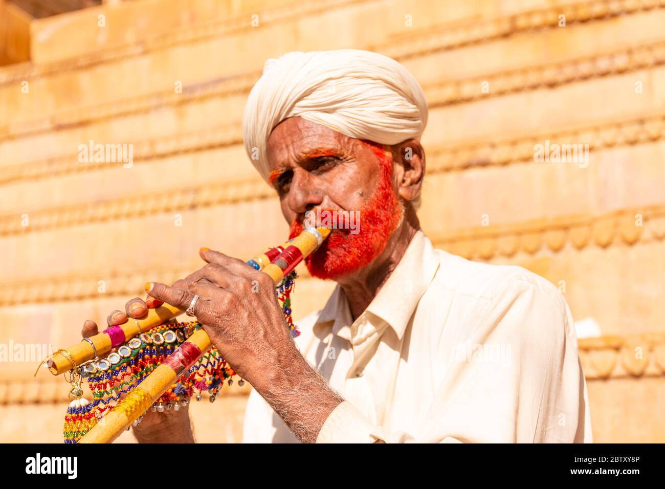 Indian old male musician artist playing decorated flute at Jaisalmer ...