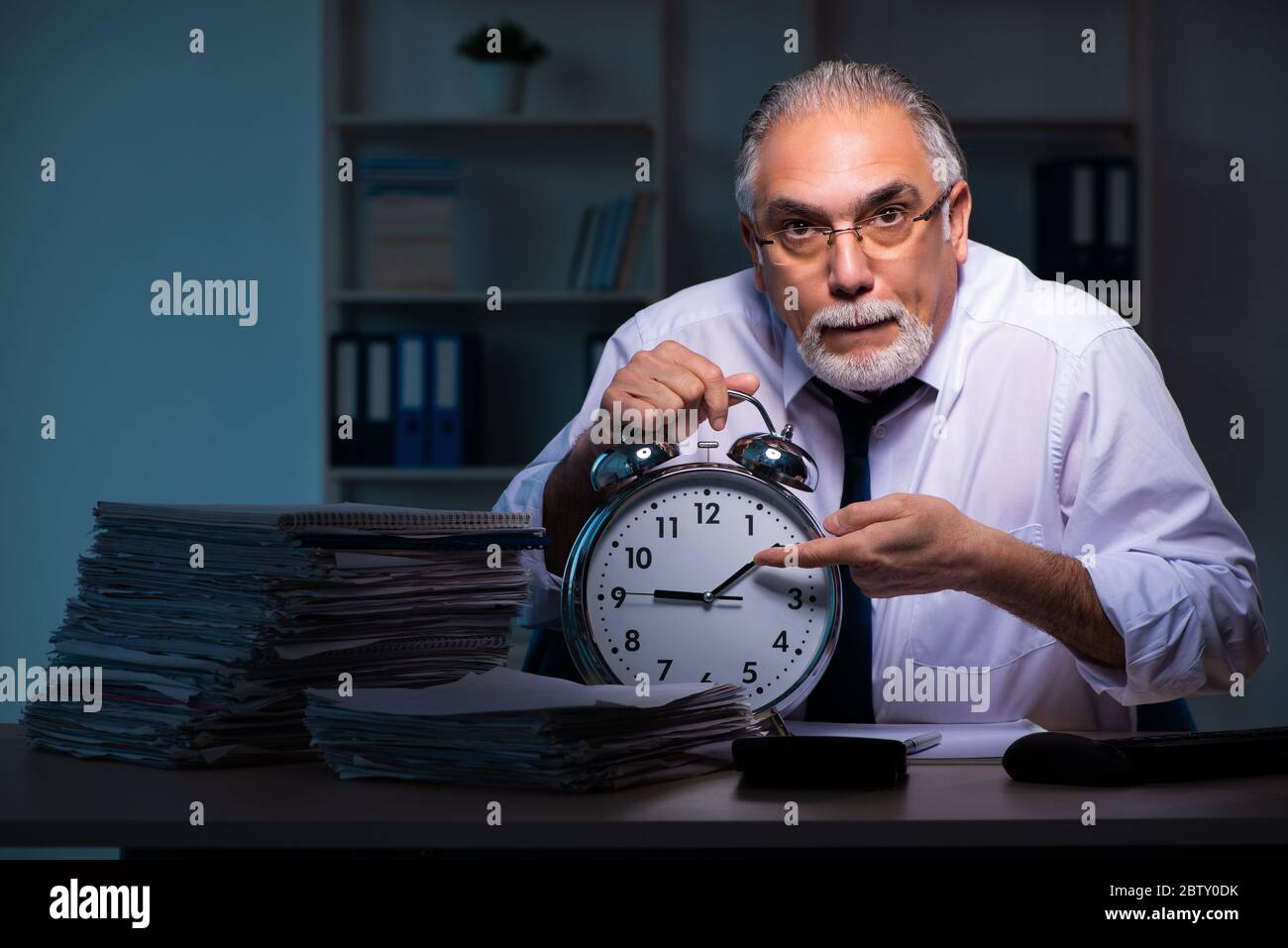 Old employee working late in the office Stock Photo - Alamy