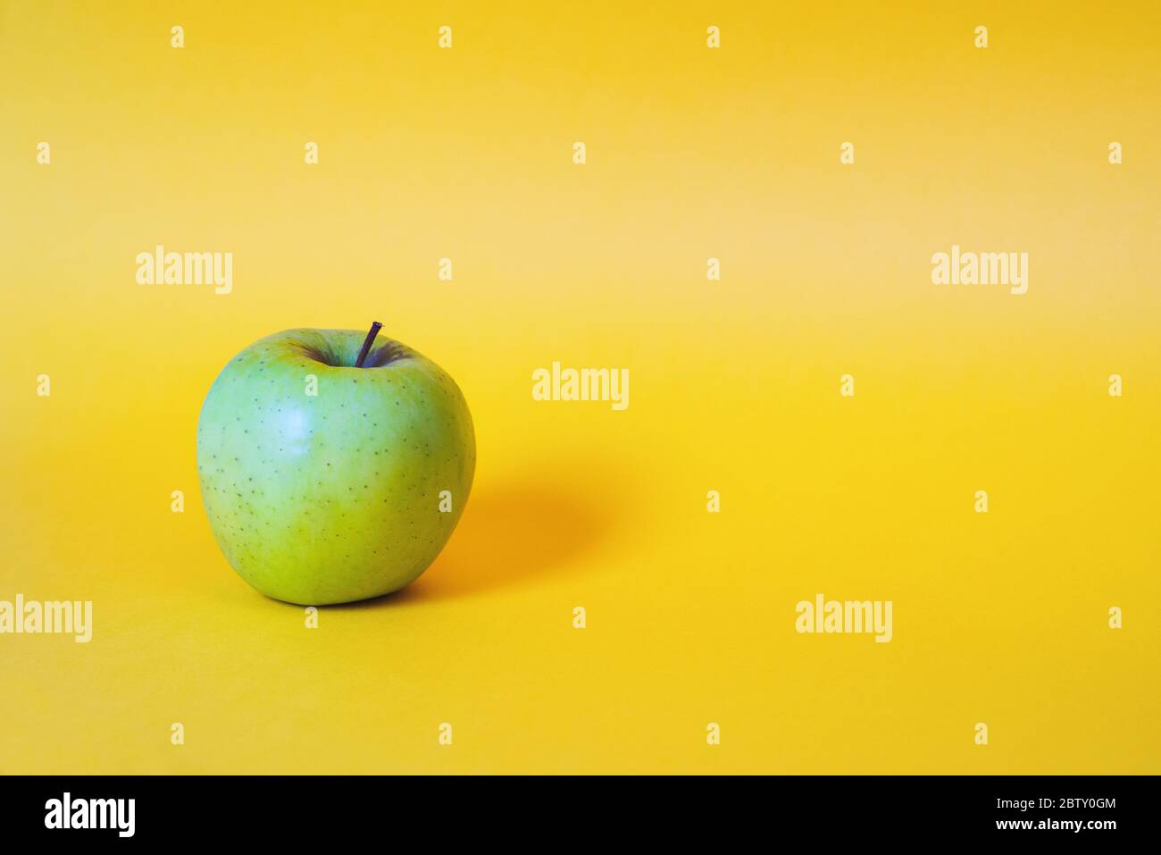 Single apple on yellow background Stock Photo - Alamy