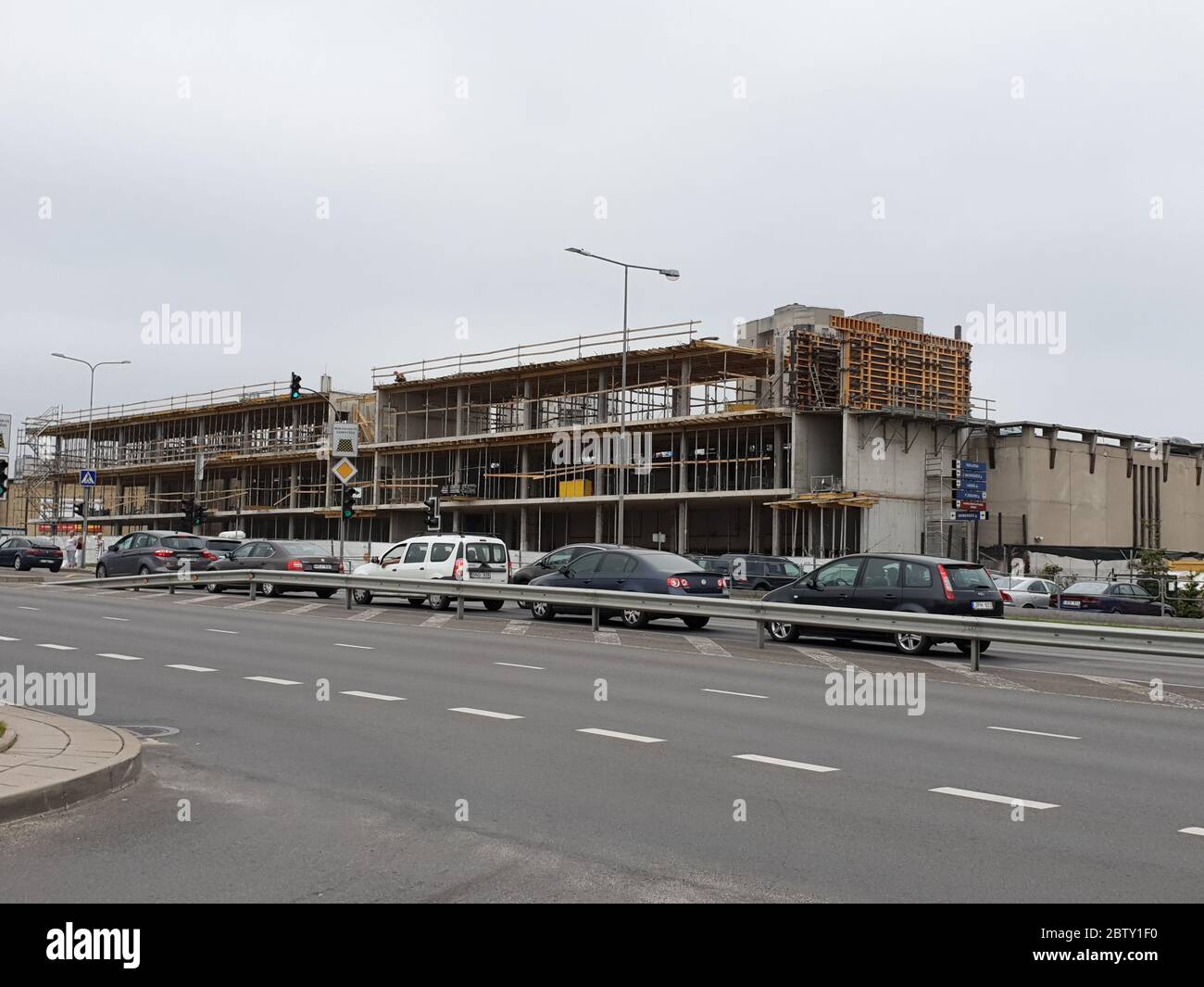 Cars on the road and new building construction in the background Stock ...