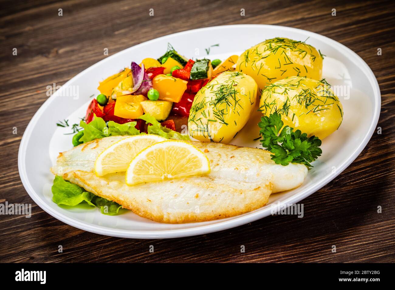 Fish dish - fried fish fillets with boiled potatoes and grilled ...