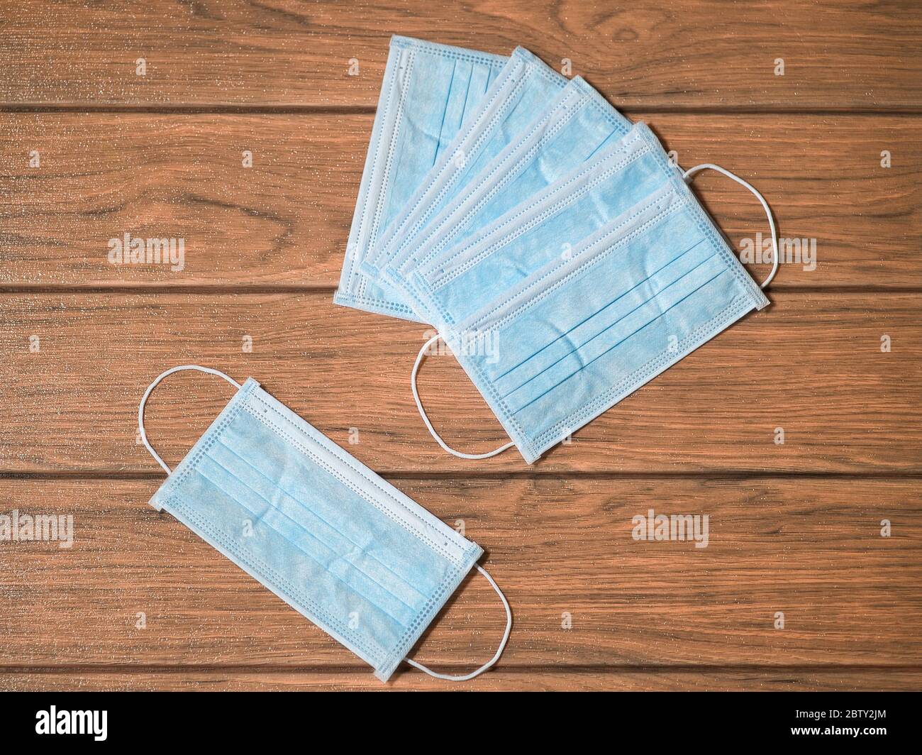 Disposable surgical masks with ear-loop and many masks on a table wood ...
