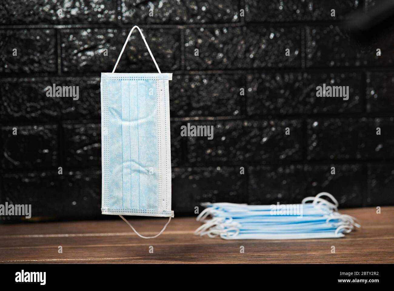 Blue disposable surgical face masks with ear-loop falling down with ...