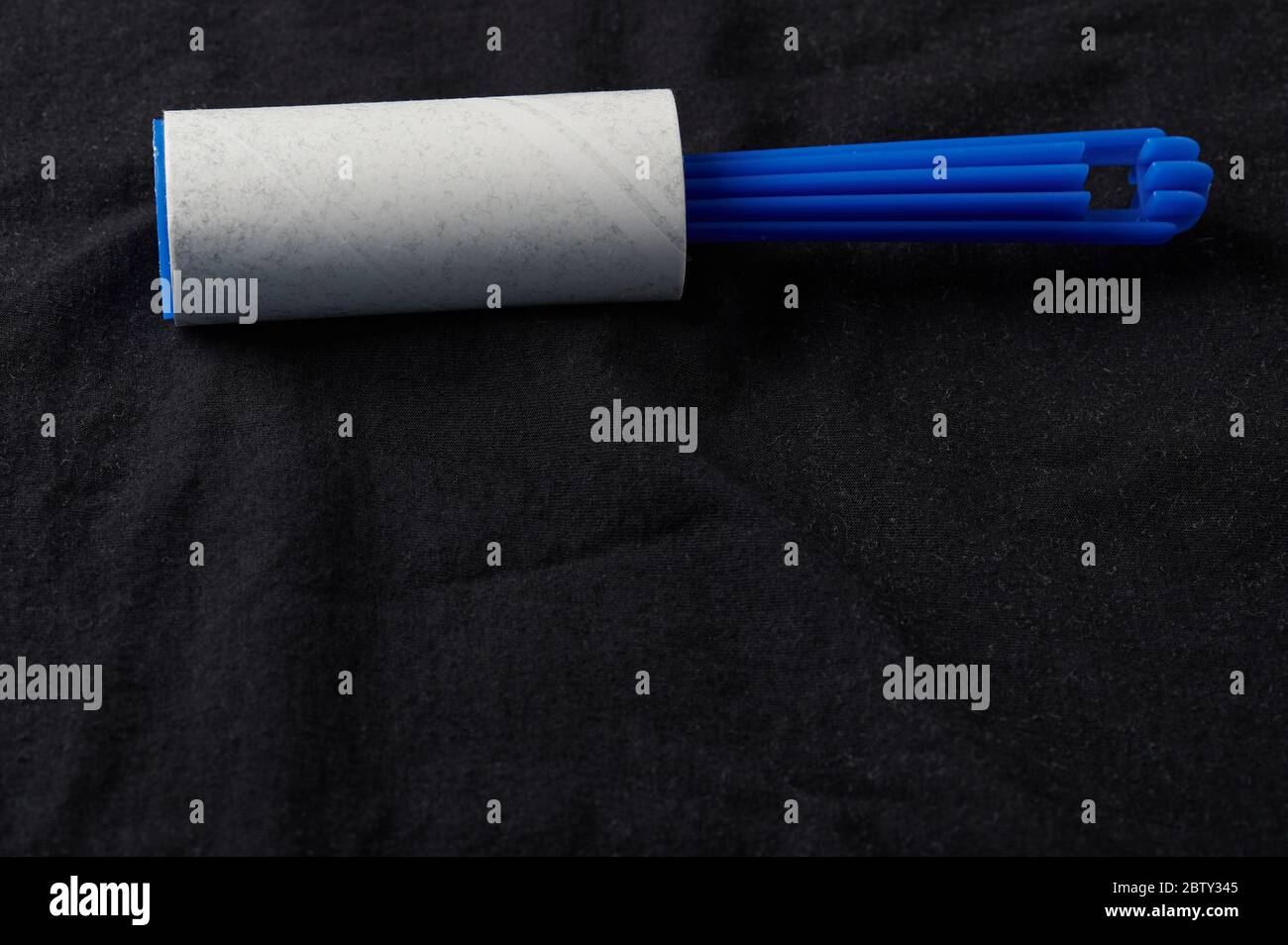 Roller sticky brush on black clean fabric background Stock Photo - Alamy