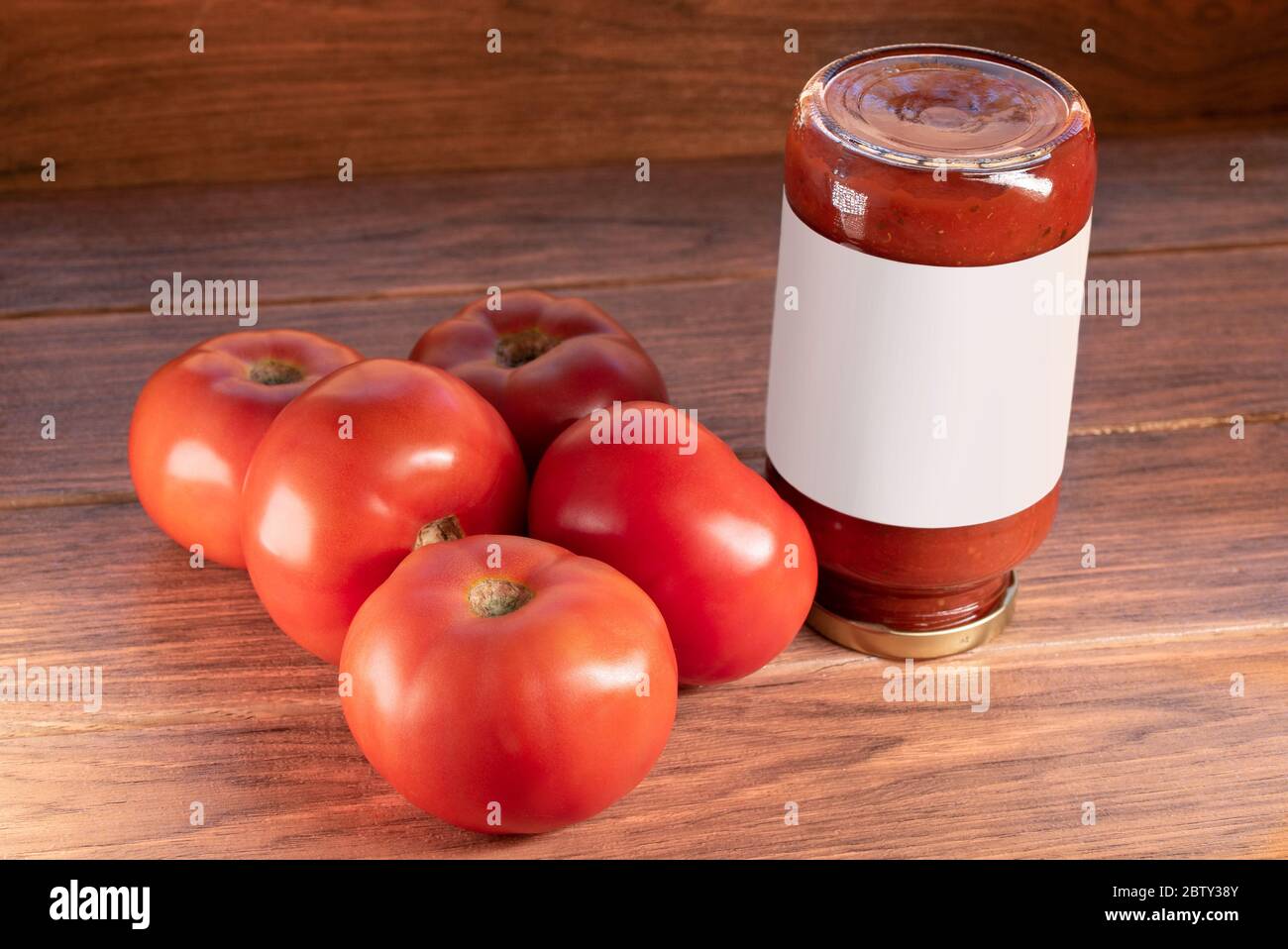 many fresh red tomatoes with a glass of tomato paste wood background ...
