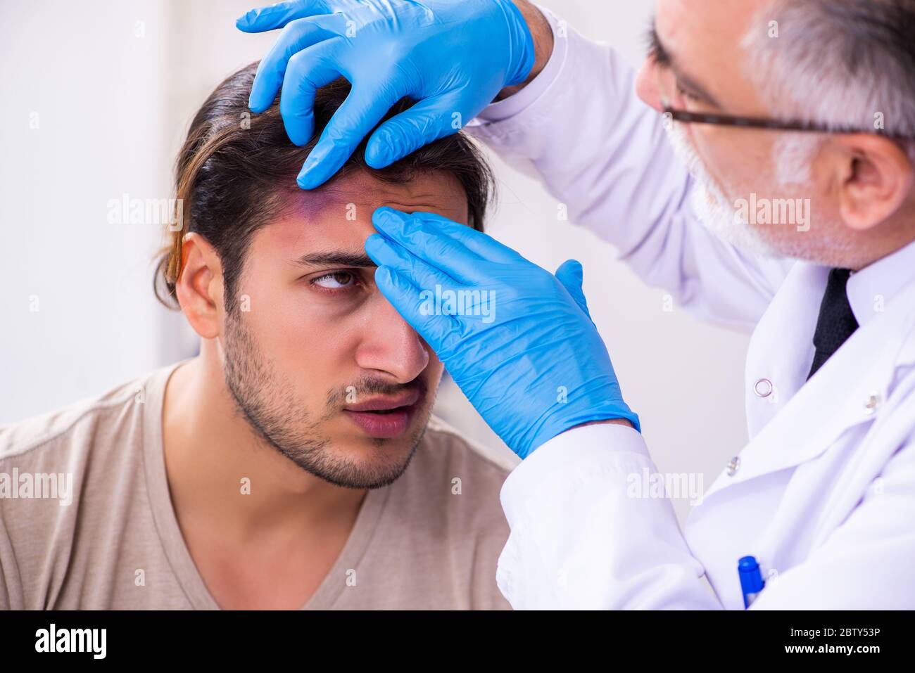 Young face injured man visiting experienced male doctor traumatologist ...