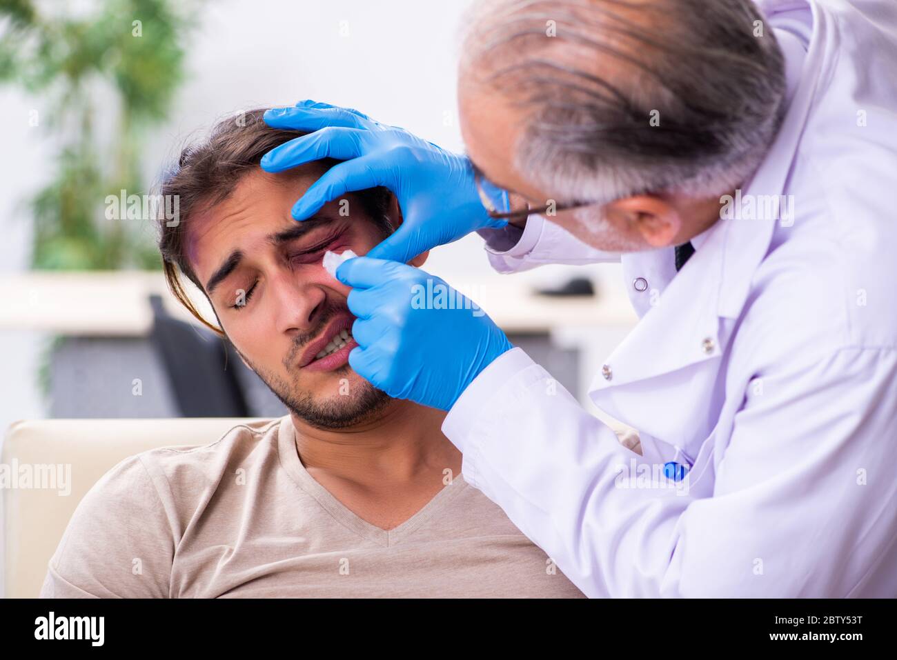 Young face injured man visiting experienced male doctor traumatologist ...