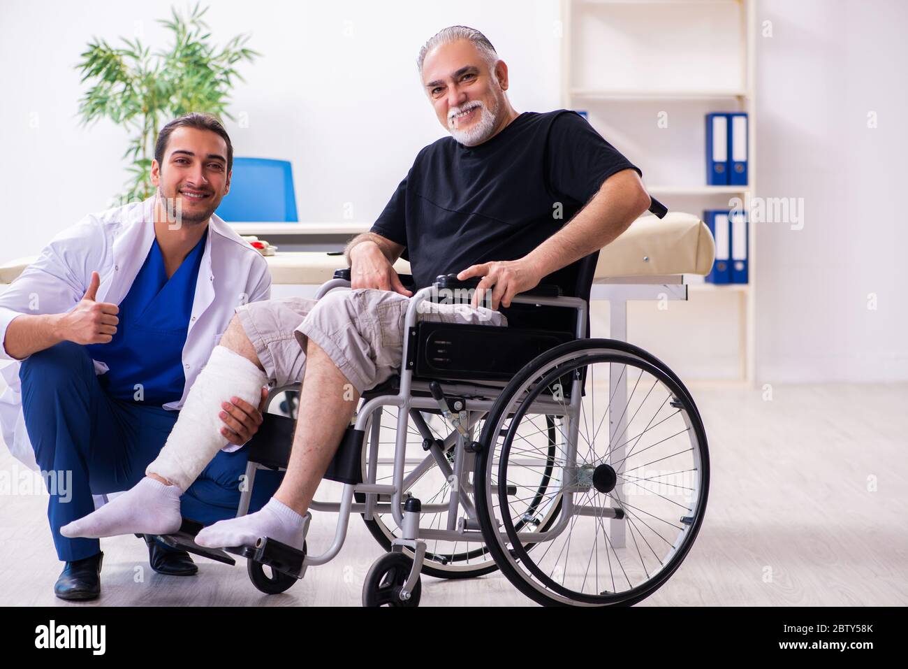 Old injured man visiting young doctor traumatologist Stock Photo - Alamy