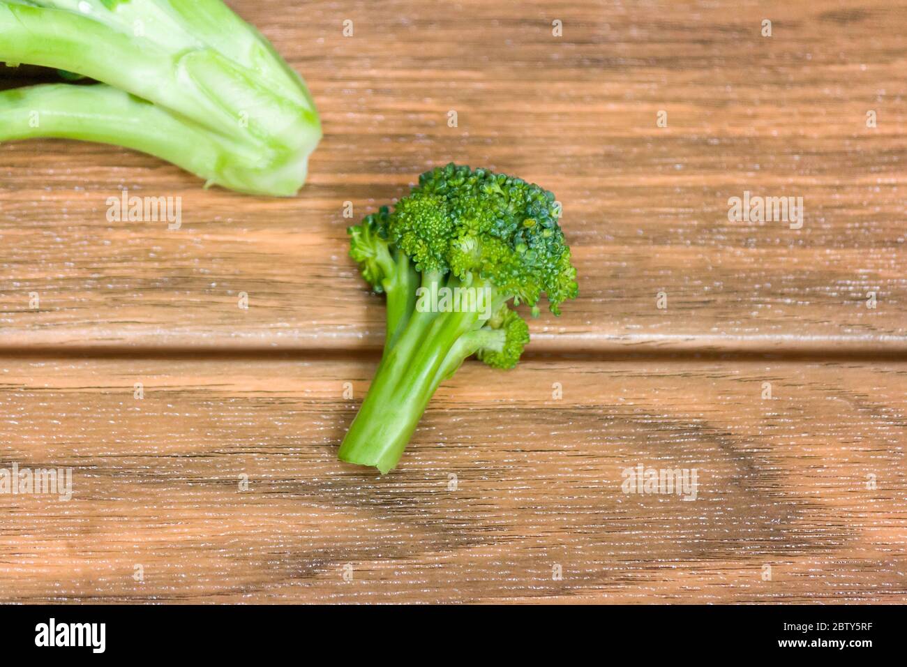 a piece of green broccoli top view with a piece of broccoli in one ...