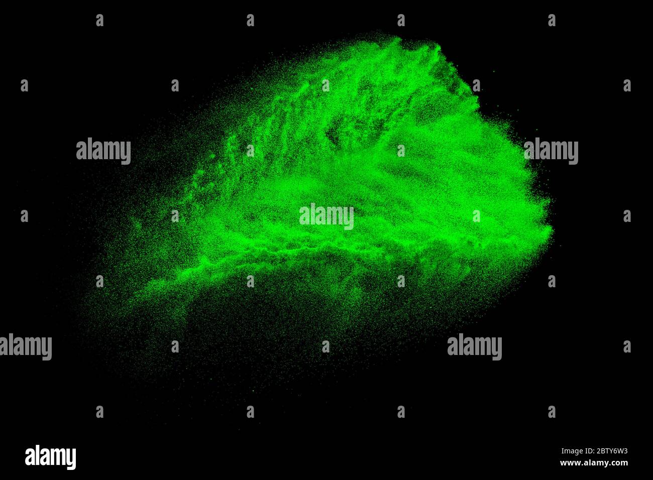 Abstract splash of green colored powder on black background.Green ...