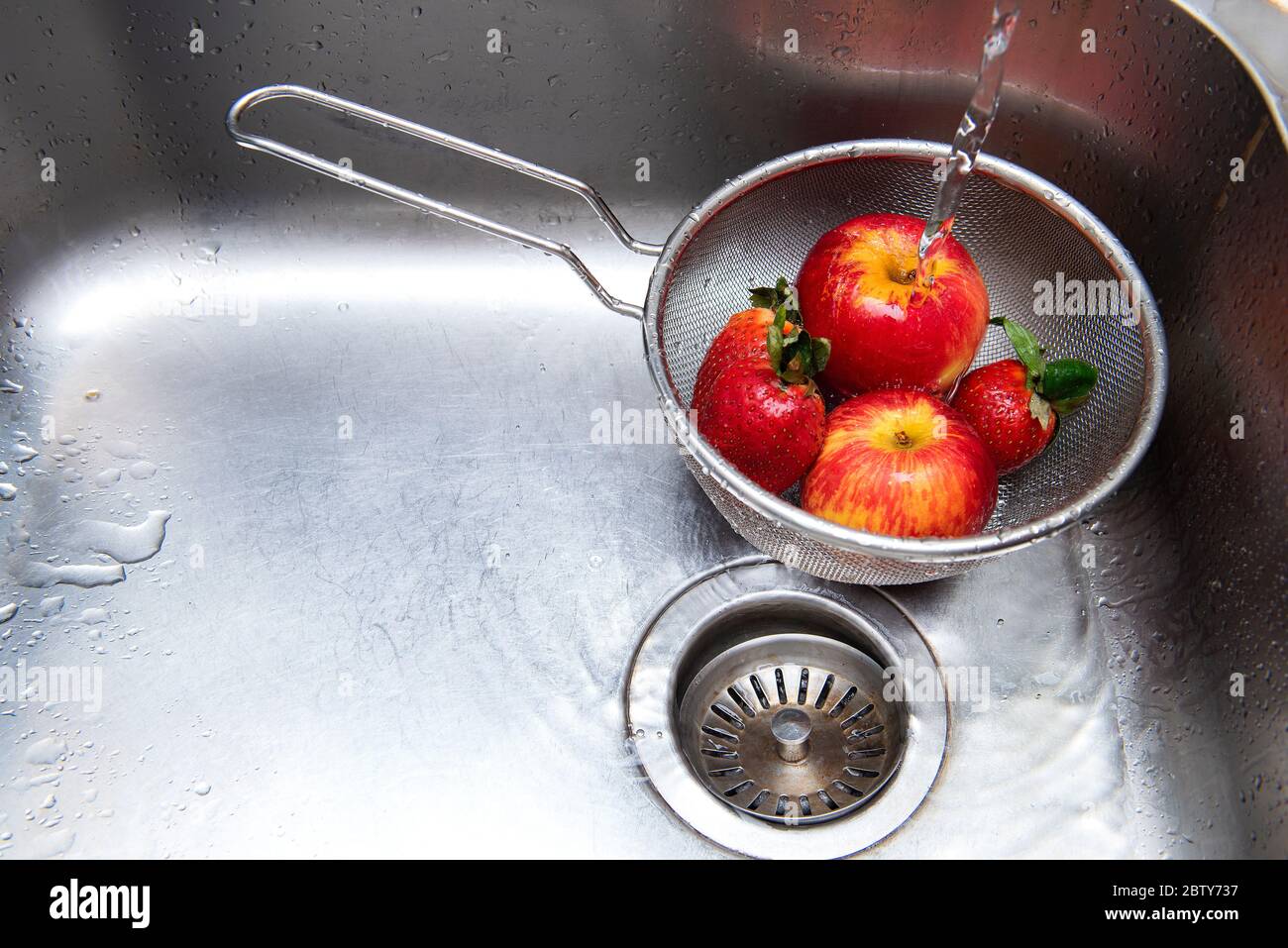 Washing fruits in the kitchen sink Stock Photo - Alamy