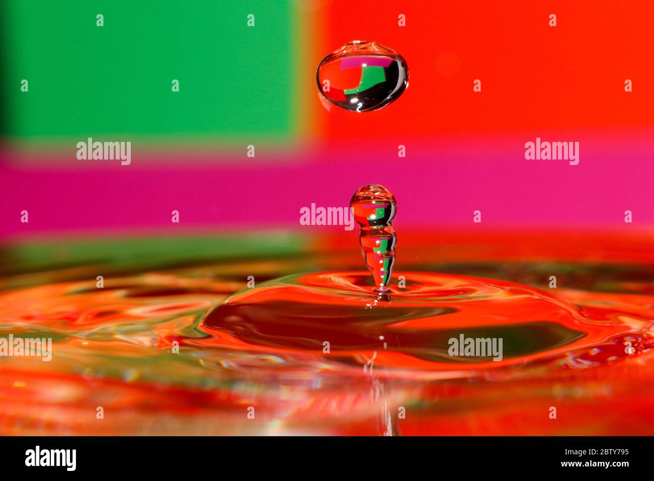 Drop of water with red green background Stock Photo - Alamy