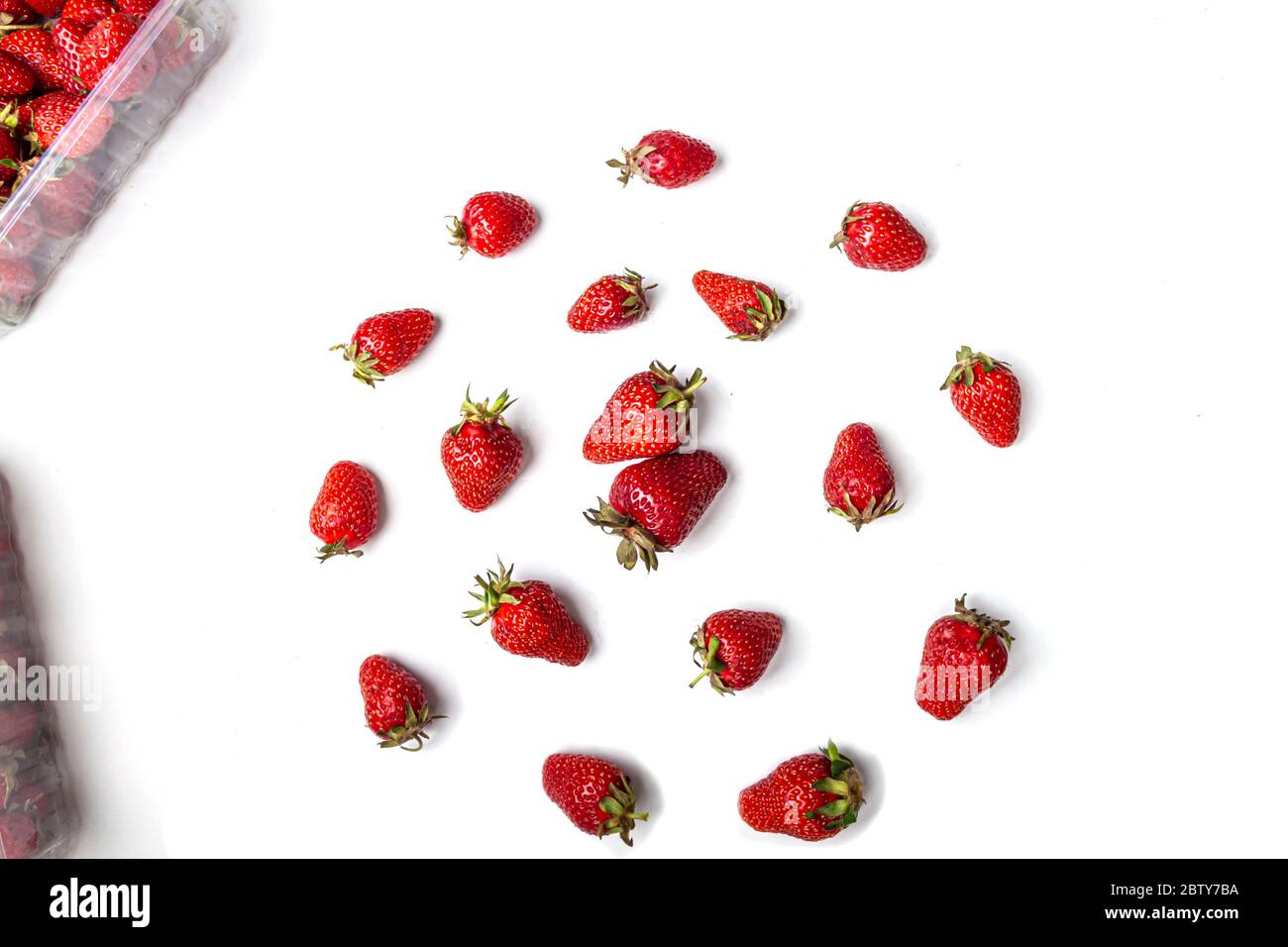 Top view of fresh tasty strawberries in plastic container and several ...