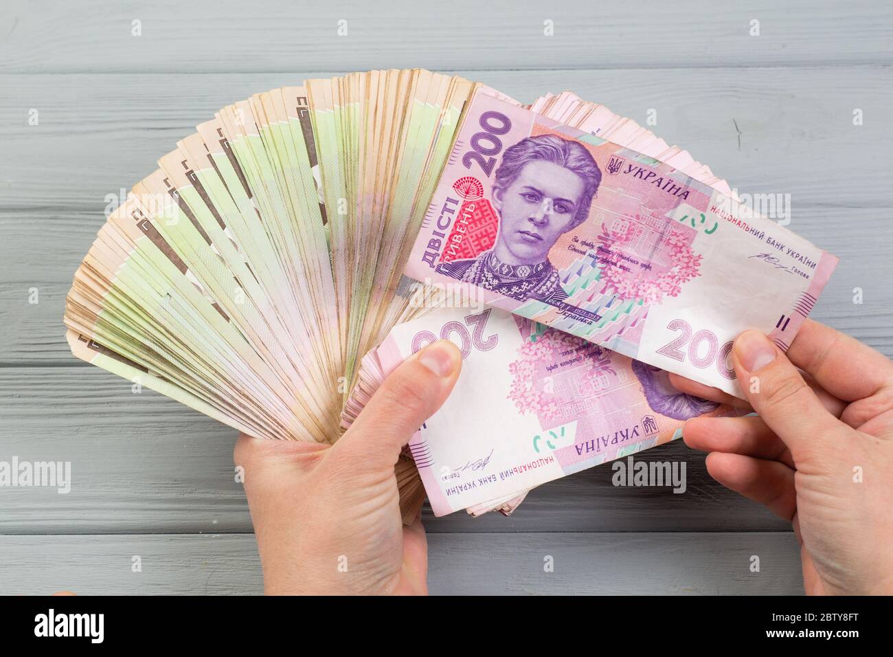 Money of Ukraine. Stack of ukrainian hryvnia banknotes in hands on ...
