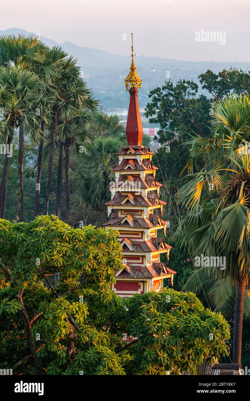 Top of a pagoda rises out of the forest, Kyaikthanian paya, Mawlamyine ...