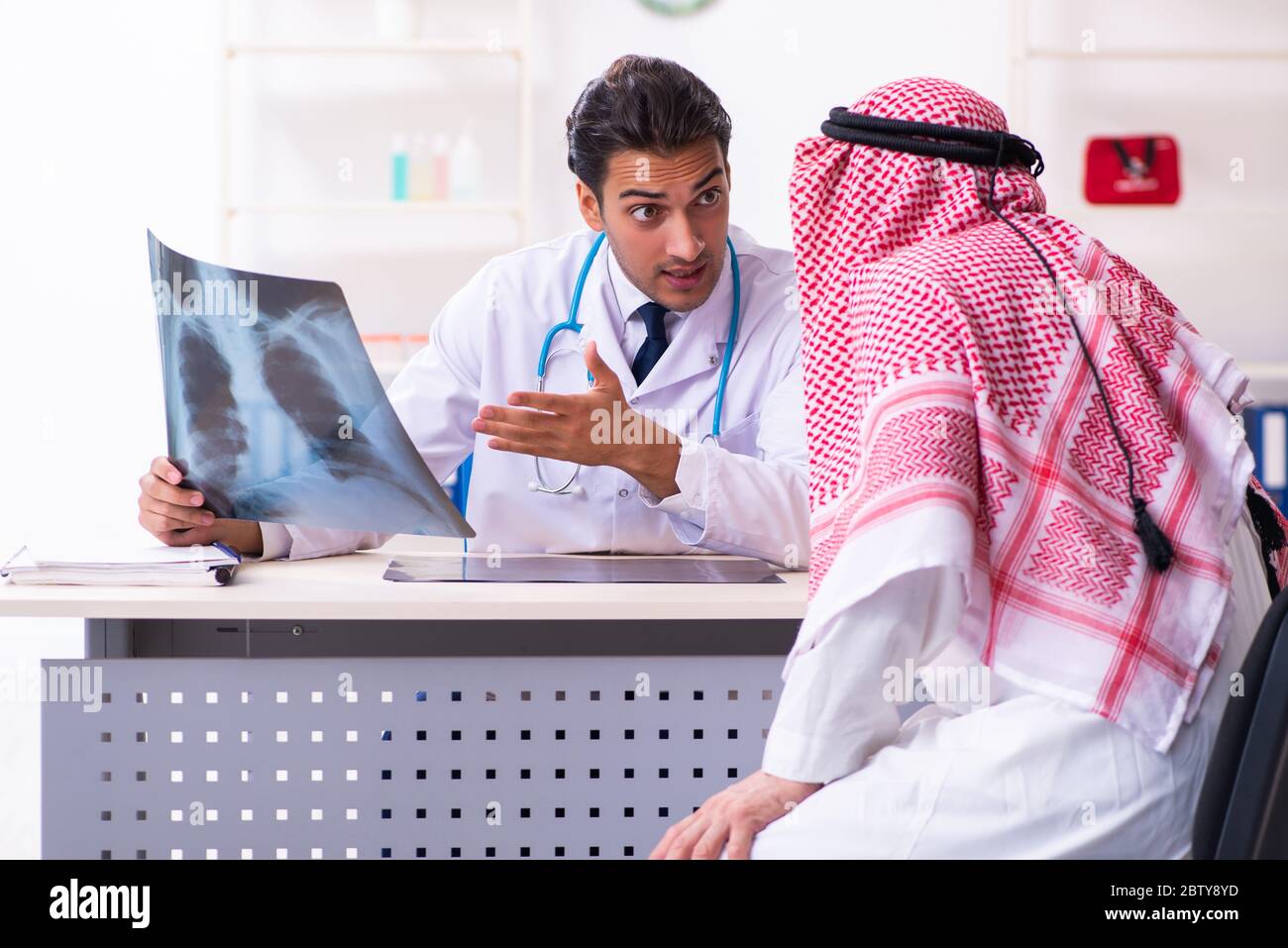 The old male arab visiting young male doctor Stock Photo - Alamy