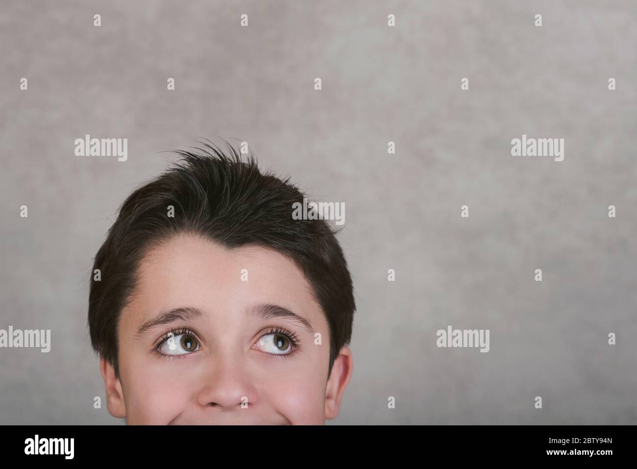 happy smiling boy looking up over gray background Stock Photo - Alamy