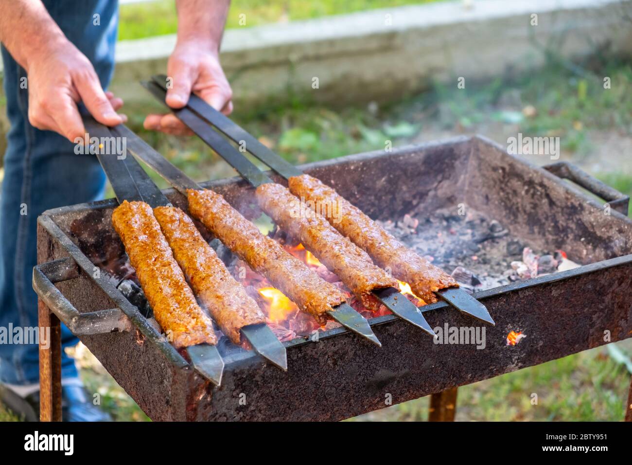 Traditional Turkish Adana Kebap on the grill with skewers for dinner ...