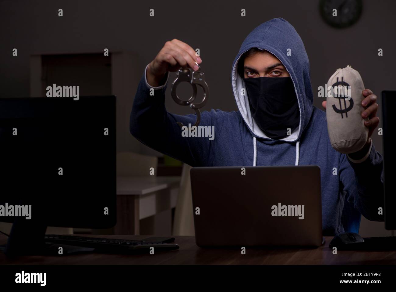 Male hacker hacking security firewall late in the office Stock Photo ...