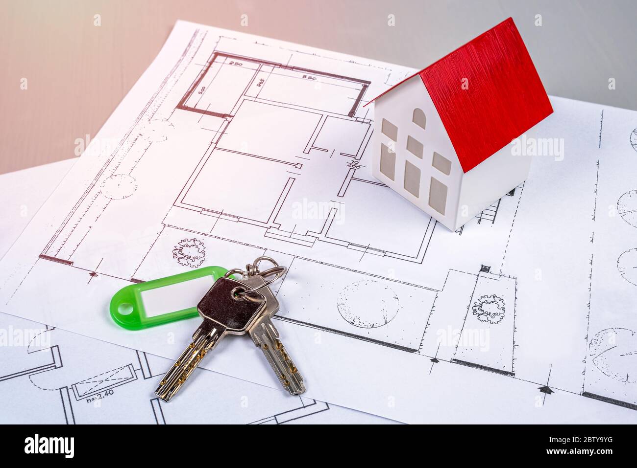 Model house and keys lying on house blueprints on a desk. Real estate ...