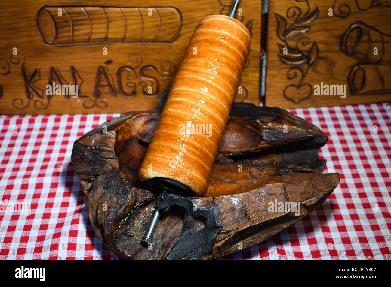 Kurtos kalacs or chimney cakes, preparing cooking on charcoal grill ...