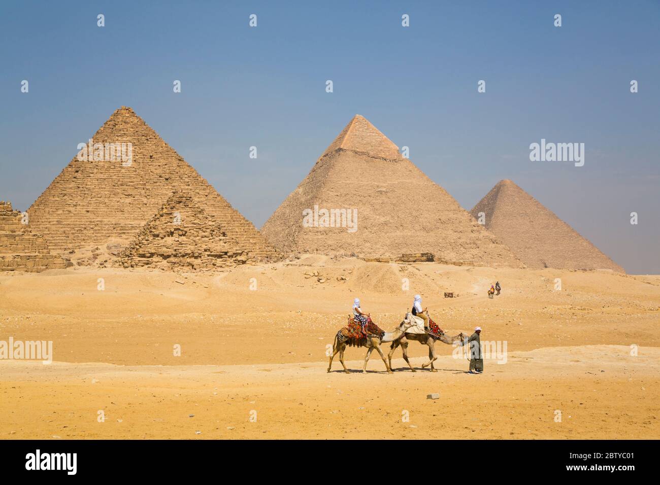 Tourists riding camels, Great Pyramids of Giza, UNESCO World Heritage ...