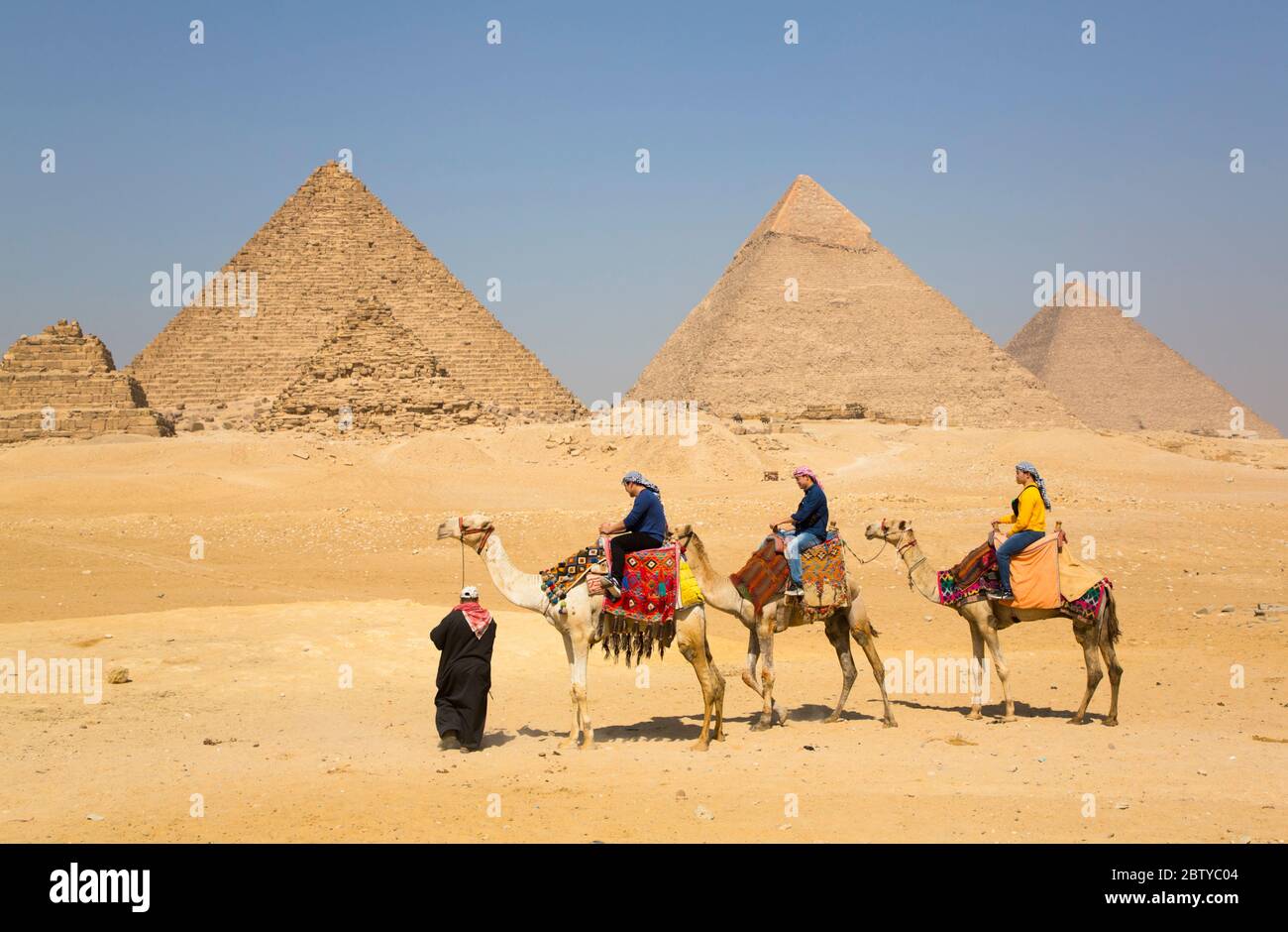 Tourists riding camels, Great Pyramids of Giza, UNESCO World Heritage ...