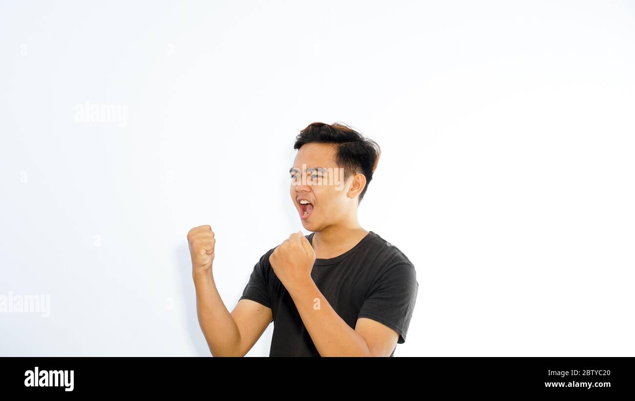 Asian man raising his hand on the right side celebrated and saying yes ...