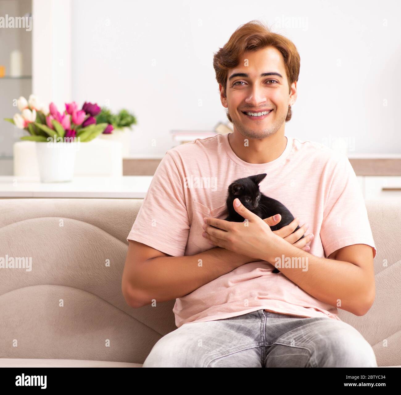 Handsome man playing black cat hi-res stock photography and images - Alamy