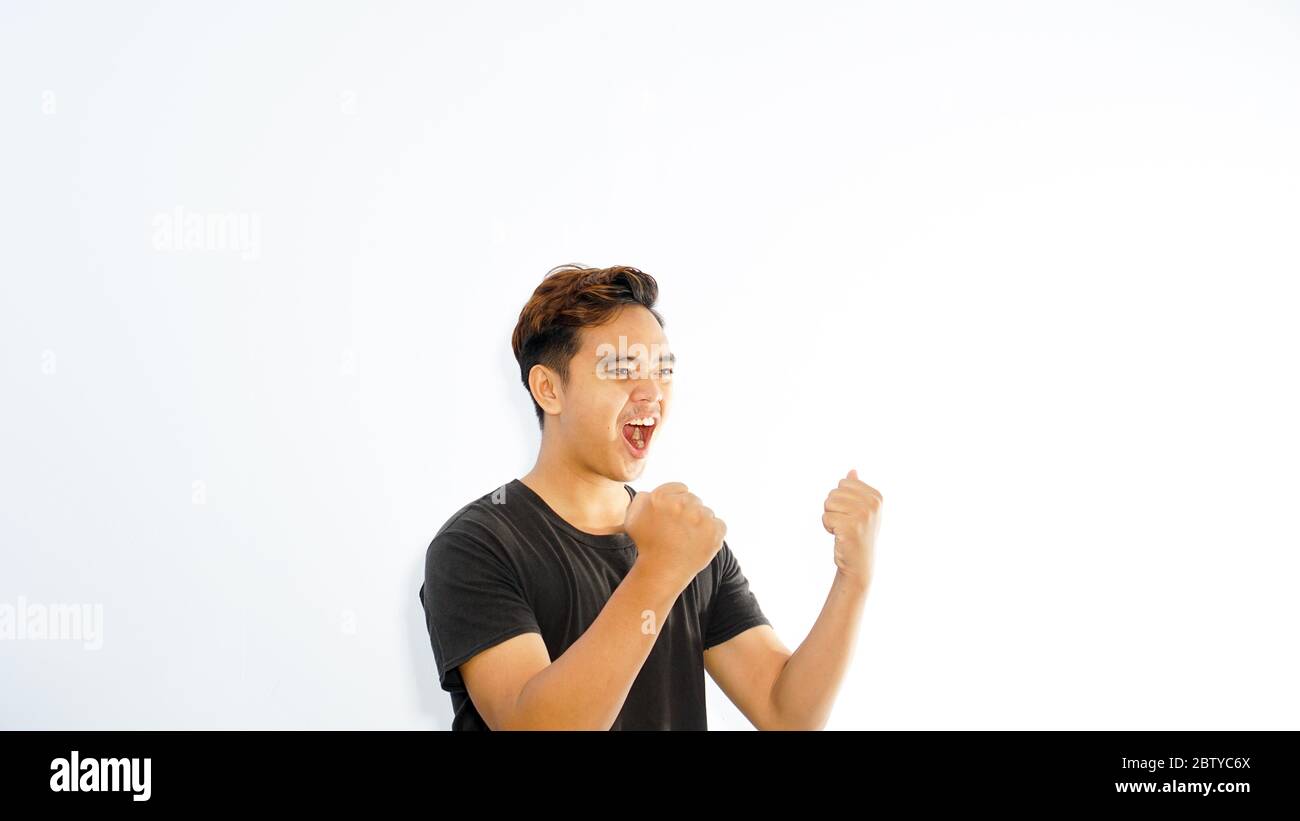 Asian man raising his hand on the left side celebrated and saying yes ...