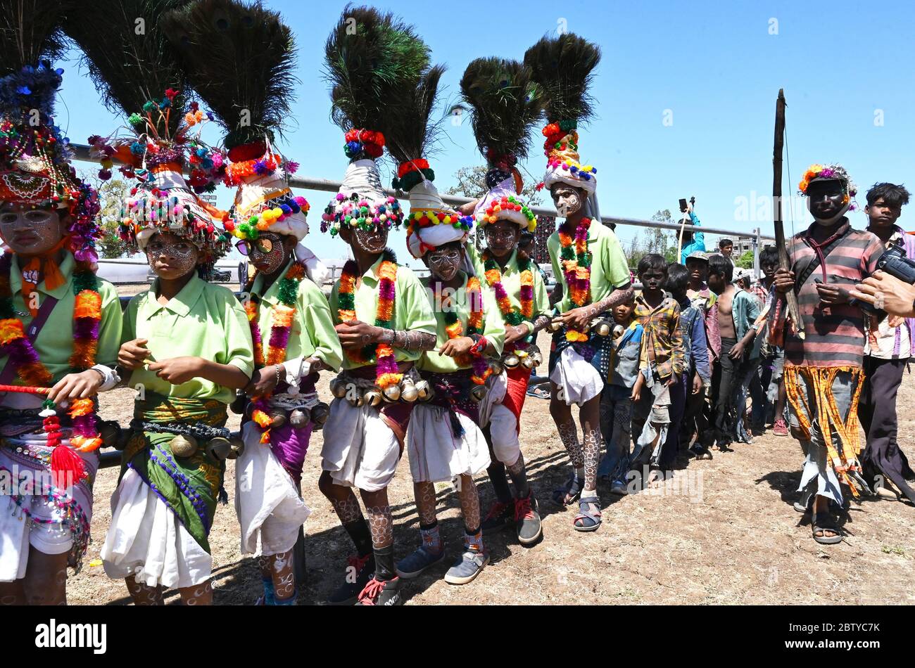 Adivasi tribal men, faces and bodies decorated, wearing ornate headgear ...