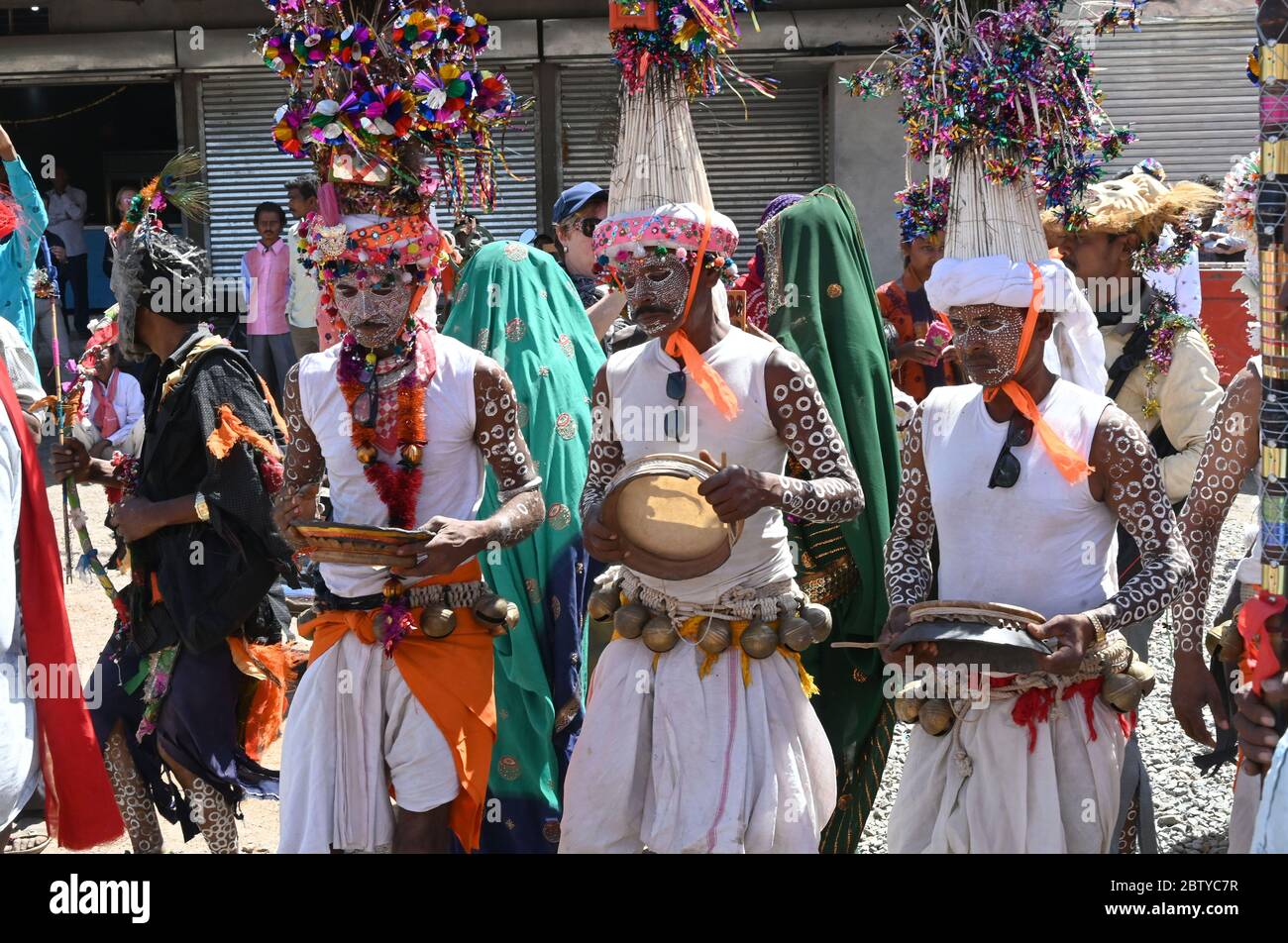 Adivasi tribal men, faces and bodies decorated, wearing ornate headgear ...