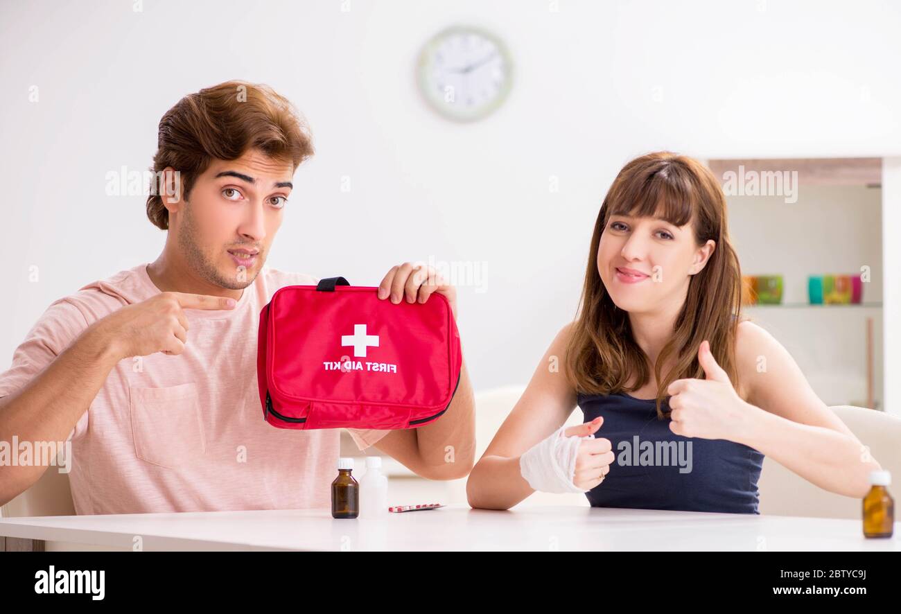The young family getting treatment with first aid kit Stock Photo - Alamy