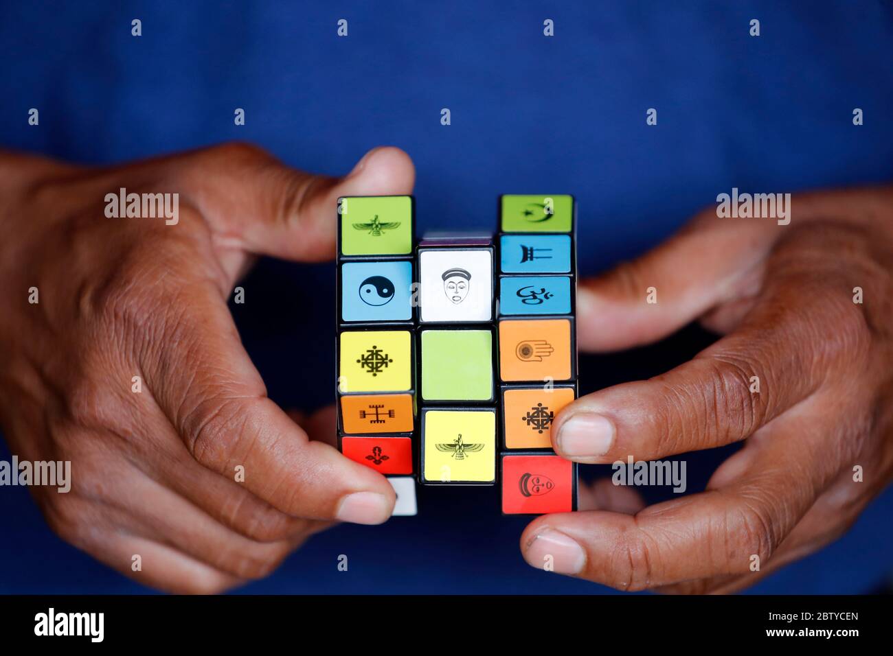 African man with a Rubik's cube with religious symbols, Interreligious ...