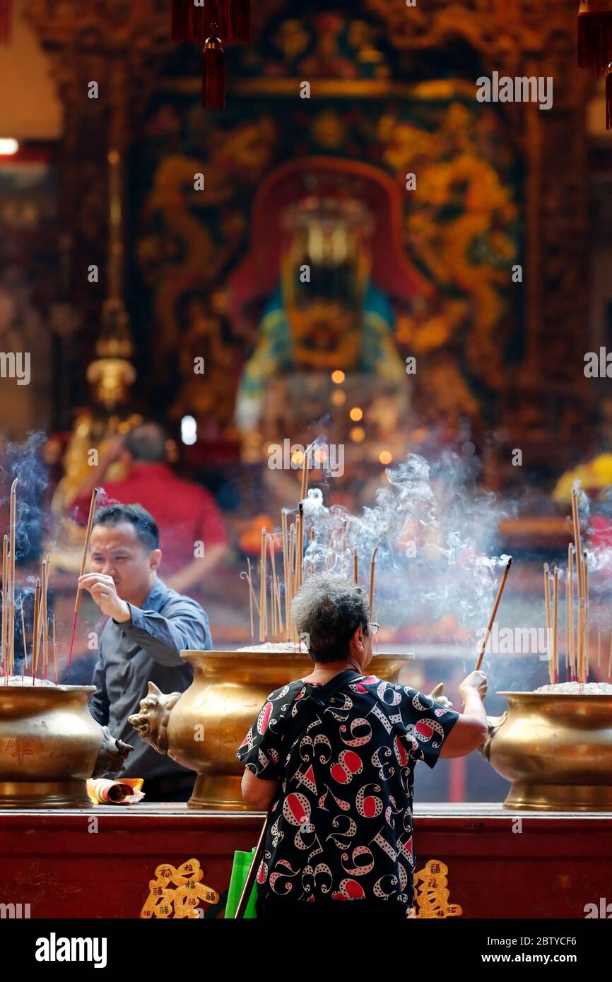 Chinese man burning incense and praying to a prosperous future, Guan Di ...